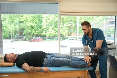 Physical Therapist Assessing Lower Extremity Muscle Strength In Patient