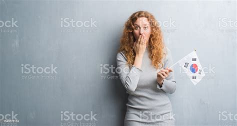 한국 커버 입 손으로 실수 두려움 침묵 비밀 개념에에서 무서 워의 표현에 대 한 수치심과 충격의 국기를 들고 회색 그런 지 벽에