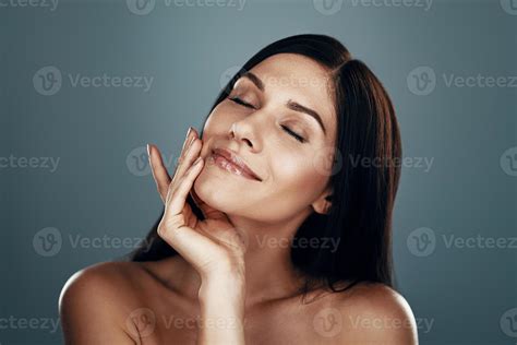 Beautiful Young Smiling Woman Touching Her Face And Keeping Eyes Closed