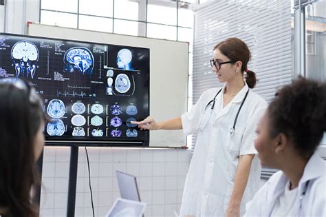 뇌 연구실에서 Mri Ct가 뇌 영상을 스캔하는 모니터로 만나는 여성 의과학자들 의사 그룹이 뇌 환자의 치료에 대해 논의하고 모니터에 이미지를 보여줍니다 20 24세에 대한