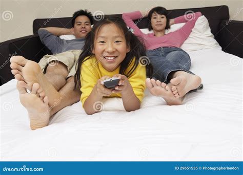 Familia Que Ve La TV Junto Imagen De Archivo Imagen De Adulto