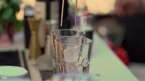 The Waiter Or Bartender Mixing Cocktail In Glasses Drinking Straw