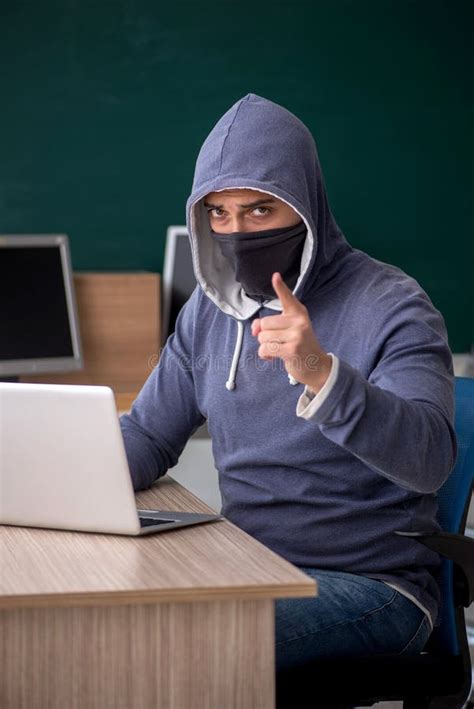 Jovem Hacker Do Sexo Masculino Sentado Na Sala De Aula Foto De Stock
