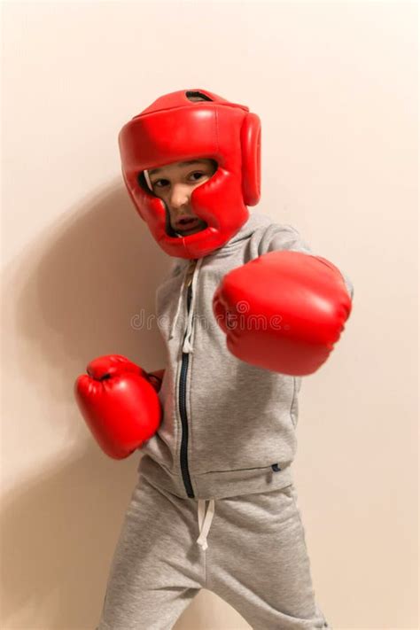 El Boxeador Joven Del Muchacho En Guantes De Boxeo Rojos Golpea Con El