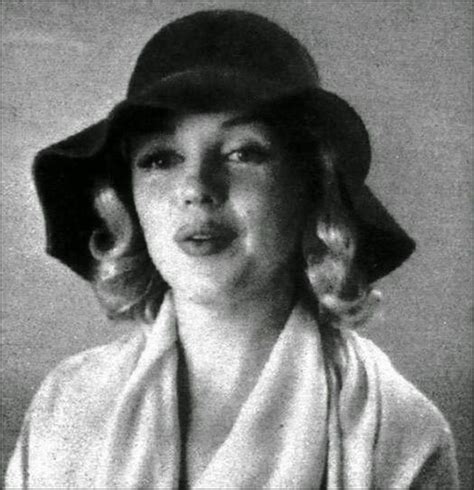 An Old Black And White Photo Of A Woman Wearing A Hat