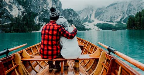 Braies 이탈리아의 고산 호수를 방문하는 보트에서 낭만적 인 커플 사랑에 빠진 관광객은 가을 산에서 함께 사랑의 순간을
