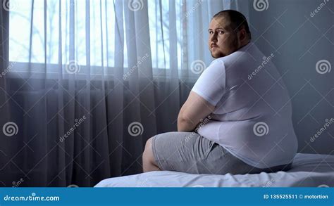 Sad Fat Man Sitting On Bed At Home Looking At Camera Depression Insecurities Stock Image