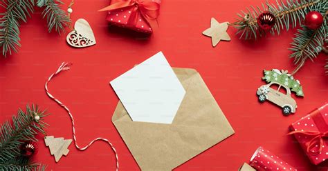 내부에 빈 카드와 크리스마스 장식 선물 빨간색 배경에 전나무 나뭇가지가 있는 종이 봉투를 만듭니다 크리스마스 편지 개념입니다 사진 Unsplash의 종이 이미지
