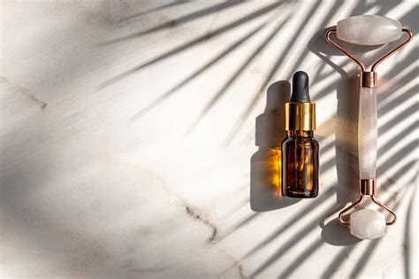 뷰티 제품의 플랫 레이 손바닥 잎 그림자 상단보기에서 대리석 배경에 얼굴 롤러 화장품 오일과 세럼 천연 화장품 및 미용 트리트먼트 대리석 효과에 대한 스톡 사진 및 기타