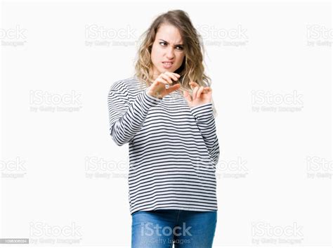 격리 된 배경 위에 줄무늬 스웨터를 입고 아름 다운 젊은 금발의 여 자가 혐오 식 불쾌 하 고 두려워 하기 때문에 역 겨 운