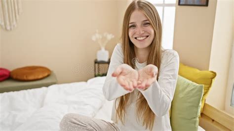 Excited Blonde Woman In Pyjamas Happily Presenting Ad Pointing Aside