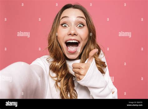 Portrait Of A Happy Young Woman Taking Selfie With Outstretched Hand