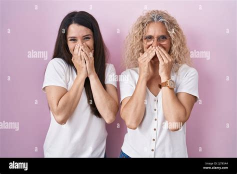 Mother And Daughter Standing Together Over Pink Background Laughing And
