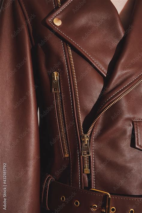 Girl In A Brown Leather Jacket With Gold Clasps And Zippers Stitched