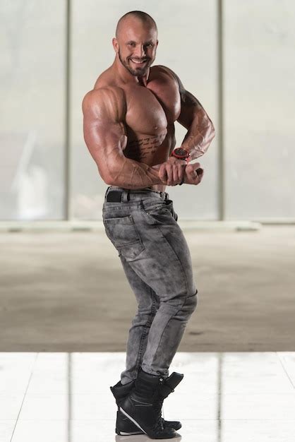 Bel Homme Musclé Flexion Des Muscles Dans La Salle De Gym Photo Premium