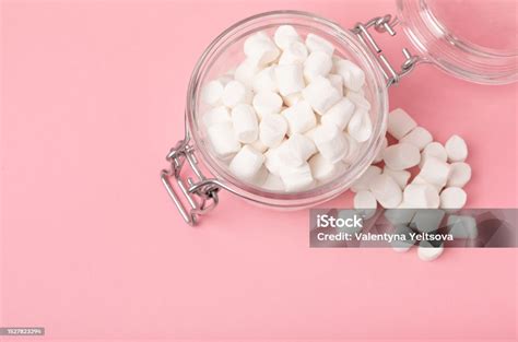 유리 그릇에 분홍색 배경에 마시멜로 하얀 마시멜로 플랫 레이 간식을위한 과자와 스낵 씹는 사탕 클로즈업 공간을 복사합니다 텍스트를위한 장소 겨울 음식 개념 개체 그룹에 대한