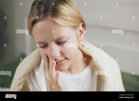 An Unhealthy Girl With A Stuffy Nose Uses A Nasal Spray To Treat A Cold