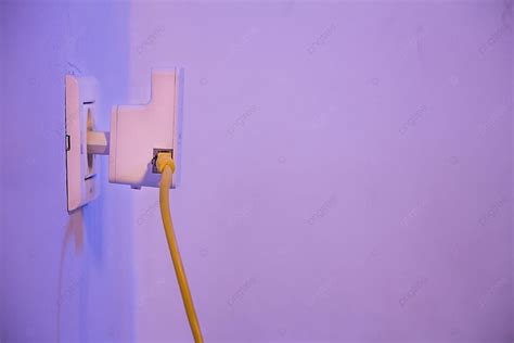 Wifi Extender In Electrical Socket On The Wall With Ethernet Cable Plugged In The Device Is In