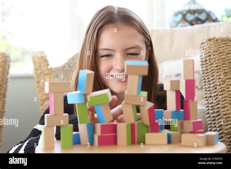 Teen Girl Pushing Over A Wall And Towers Of Wooden Blocks Knocking