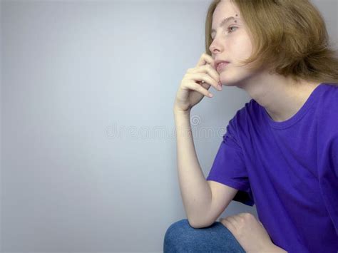 The Girl Presses Her Hand To Her Face And Looks Thoughtful And Cute