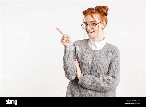 Portrait Of A Cheerful Young School Nerd Girl Pointing Finger Away At