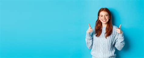 Premium Photo Cheerful Teen Girl With Red Hair Pointing Fingers At