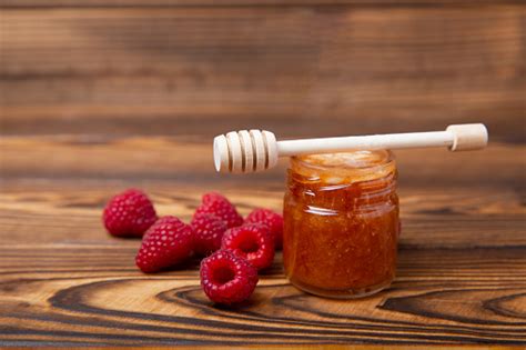 갈색 나무에 블루베리와 라즈베리를 곁들인 꿀 항아리 감기약 건강과 미용을위한 유용한 강화 잼 크림 꿀 채식주의 식단 유기농 제품 복사 공간 텍스트 배치 0명에 대한 스톡