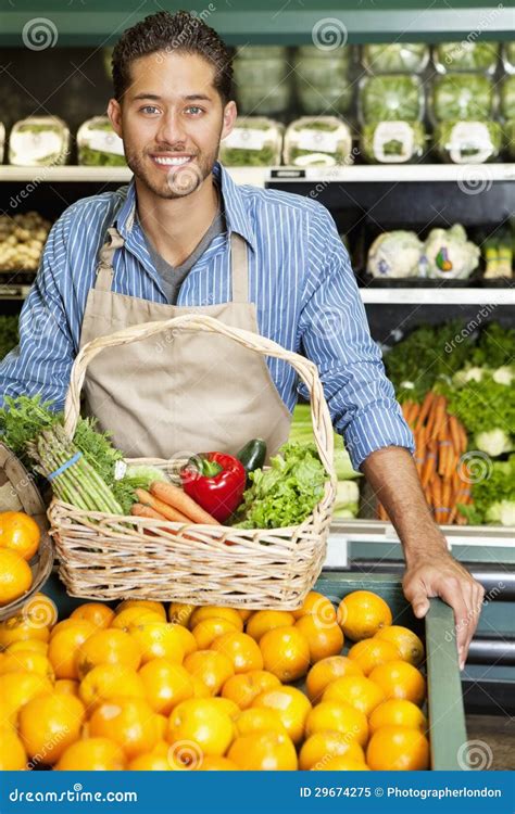 Portrait Of A Happy Man With Vegetable Basket Standing Near Oranges