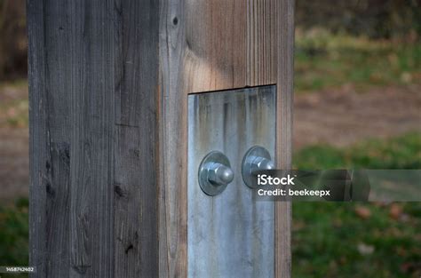 사각형 게이트 또는 프레임 모양의 거대한 목재 빔 그 사이에는 어린이를위한 그네가있는 금속 막대가 있습니다 공원 길 옆 잔디밭 지붕 금속판 공중 보도 전망 잔디밭 0명에