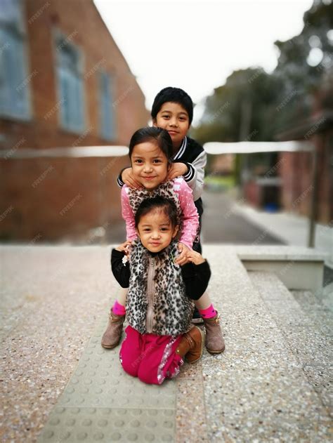 Premium Photo Portrait Of Playful Siblings On Steps At Porch