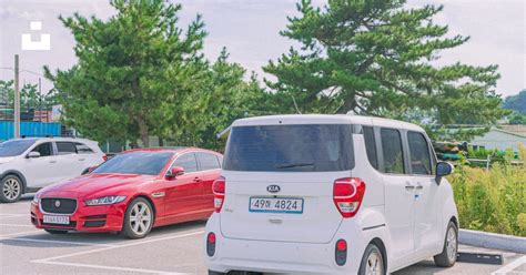 빨간 차 옆에 주차된 흰색 차 사진 Unsplash의 무료 주차장 이미지