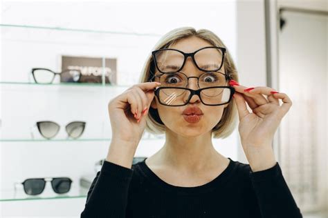 Premium Photo Woman Choosing A Pair Of Eyeglasses At Optics Store