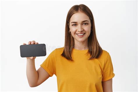 Portrait Of Attractive Young Woman Shows Horizontal Smartphone Screen Video Game Or App