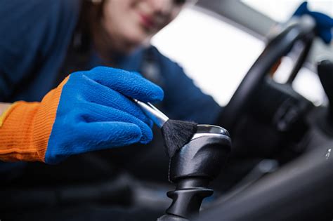 조명이 밝은 실내 공간에서 형형색색의 장갑을 낀 채 브러시로 자동차 기어 변속을 청소하는 사람 가사 집안일에 대한 스톡 사진 및 기타 이미지 Istock