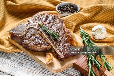 도마에 구운 T 뼈 스테이크 요리 된 트본 쇠고기 흰색 나무 배경 위쪽 보기 Steakhouse에 대한 스톡 사진 및 기타
