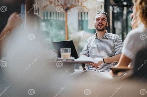 Startup Team In Business Meeting Discussing And Brainstorming Strategies In A Casual Cafe