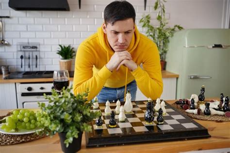 Joven Jugando Al Ajedrez En La Mesa De La Cocina Foto Premium
