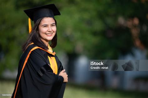 황금 가운을 입고 있는 한 여성 대학 졸업생이 졸업식 날 검은 모자를 쓰고 있다 교실에 대한 스톡 사진 및 기타 이미지 교실 교육 노랑 Istock