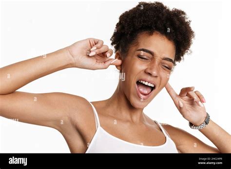 Young Black Woman In Tank Top Screaming And Plugging Her Ears Isolated