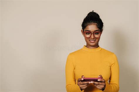 Joven Morena India Mujer Sonriendo Y Usando Celular Imagen De Archivo