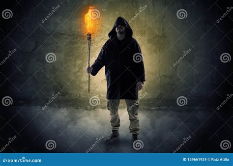 Wayfarer With Burning Torch In Front Of Crumbly Wall Concept Stock