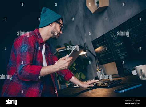 photo of serious busy coder dressed hat glasses connecting ereader to