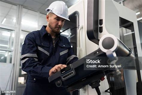 남성 엔지니어가 공장의 모니터에서 Cnc 기계를 제어합니다 공장에서 안전 유니폼과 헬멧을 착용한 선반 기계로 작업하는 남성 공장 노동자 사람들에 대한 스톡 사진 및 기타