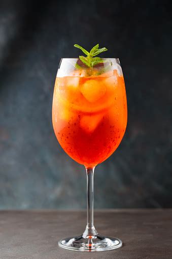 어두운 배경에 오렌지와 신선한 민트가 있는 유리잔에 담긴 Aperol Spritz 칵테일 이탈리아 전통 식전주 칵테일 각얼음에
