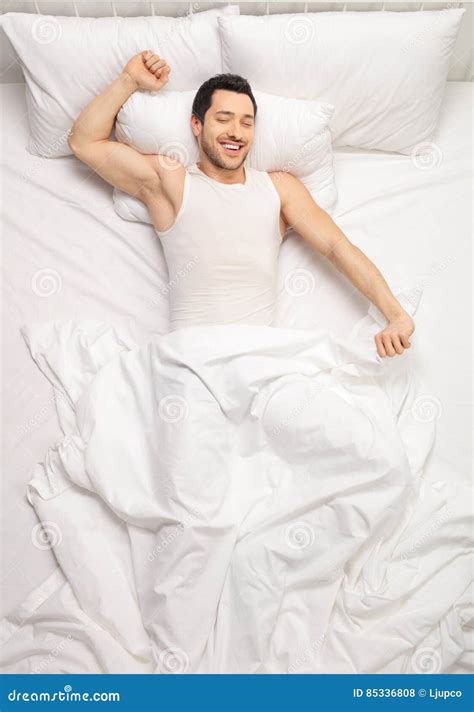 Junger Mann Der Im Bett Und Im Ausdehnen Liegt Stockfoto Bild Von