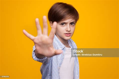 白種人男孩與薑頭髮手勢停止標誌與手掌在黃色工作室牆上 照片檔及更多 停止標誌 照片 停止標誌 兒童 男孩 Istock