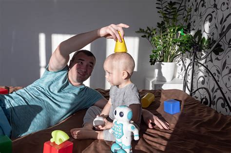 어린 소년과 그의 아빠는 방 의 내부에 파란색 담요에 바닥과 침대에서 장난감을 가지고 즐겁게 놀고있다 2 3 살에 대한 스톡 사진 및 기타 이미지 Istock