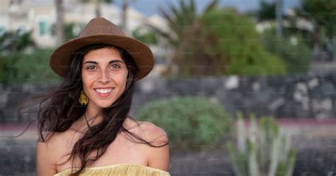 세련된 모자를 쓰고 카메라를 바라보며 아름다운 미소를 가진 행복한 라틴 여성 여름 동안 휴가를 즐기는 젊은 갈색 머리 여자 쾌활한 소녀 실제 사람들의 감정 사진