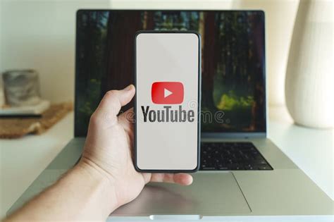 Youtube App Logo On Cellphone Screen Person Holding Youtube Application On Smartphone In Laptop