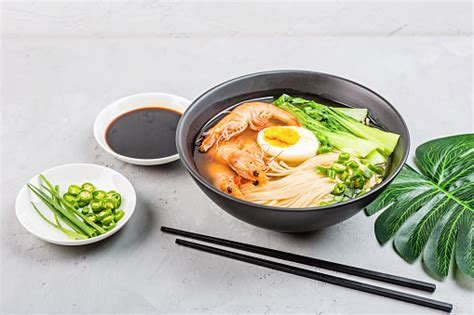 아시아 국수 수프 새우 새우 야채와 회색 콘크리트 배경에 검은 그릇에 계란을 곁들인 라면 플랫 레이 상단보기 모형 오버 헤드